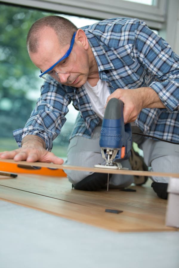 Man using saw to cut wood stock photo. Image of lumber - 124016042