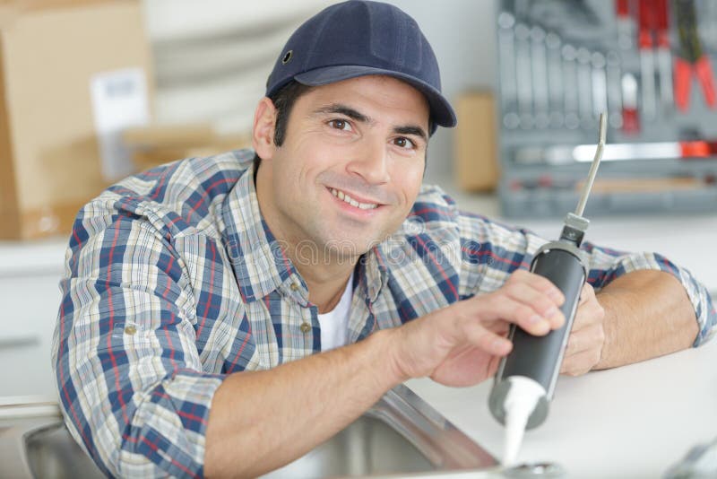 Man Using Sealant Gun in Kitchen Stock Image - Image of silicon, roof ...