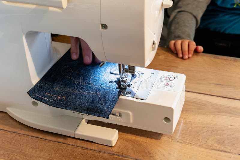 Man Using a Sewing Machine with a Blue Garment, for Repair Work ...