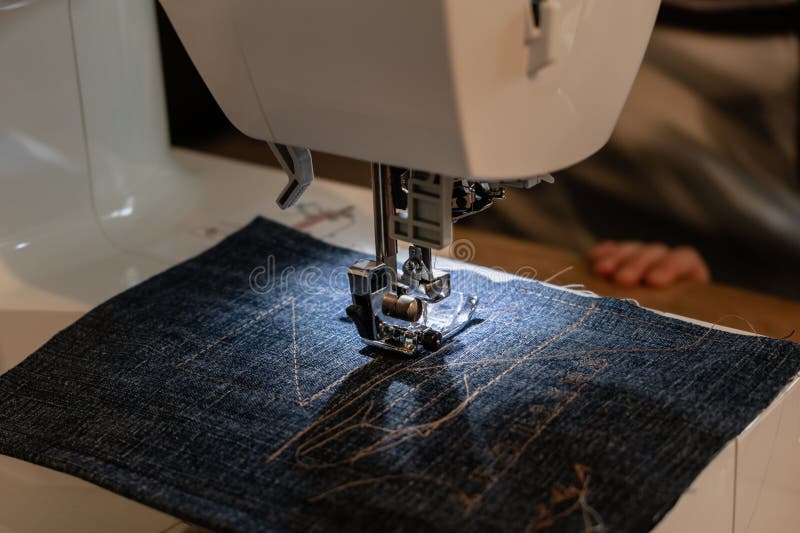 Man Using a Sewing Machine with a Blue Garment, for Repair Work ...