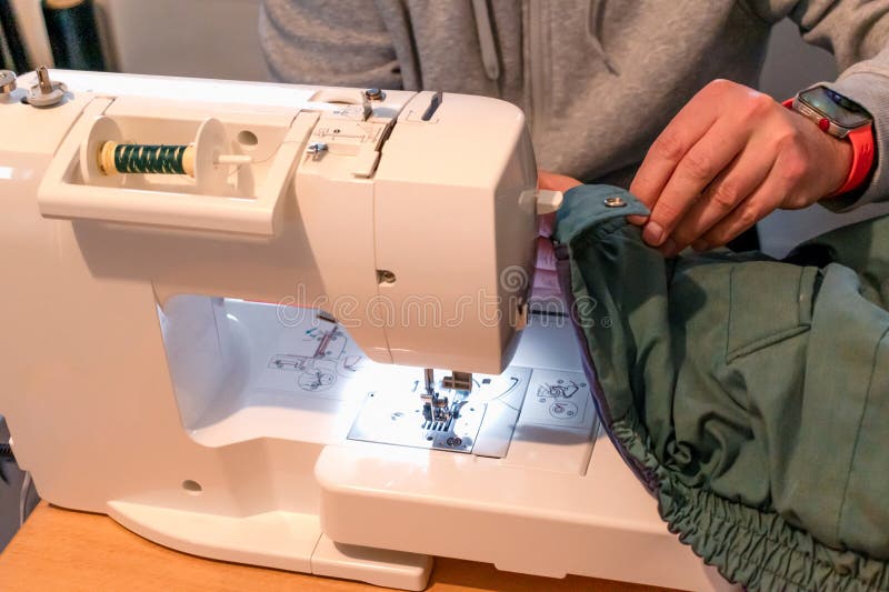 Man Using a Sewing Machine with a Garment, for Repair Work ...