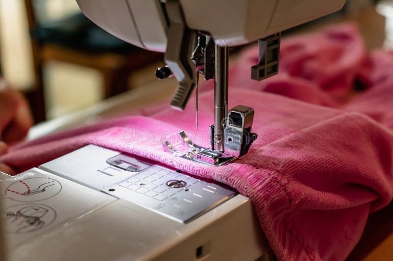 Man Using a Sewing Machine with a Pink Garment, for Repair Work ...