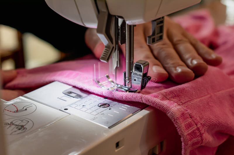 Man Using a Sewing Machine with a Pink Garment, for Repair Work ...