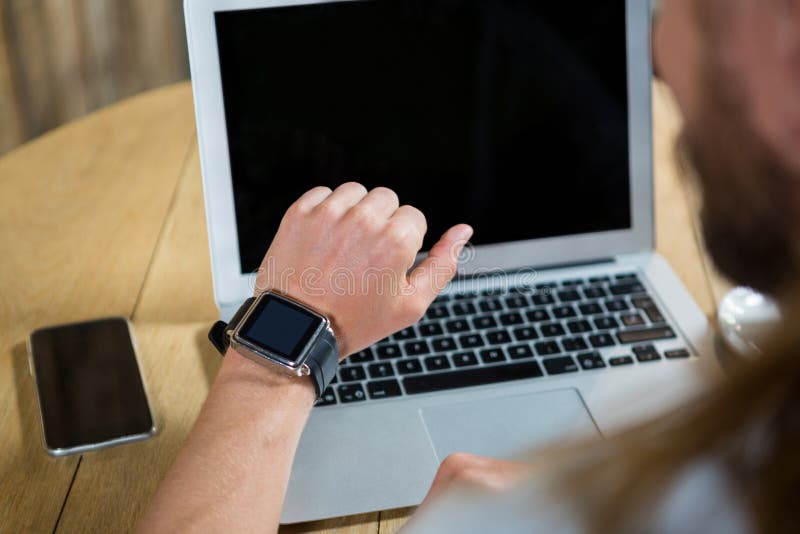 Man Using Smart Watch with Laptop and Mobile Phone on Table in Cafe ...