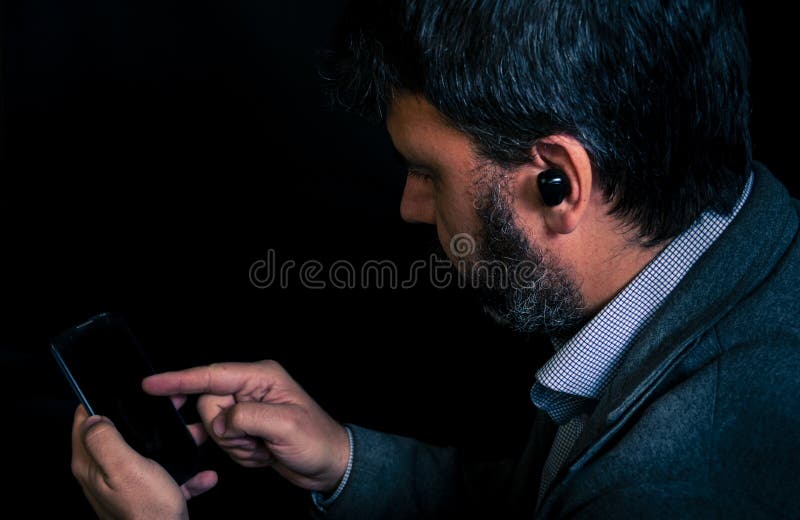 Man Using Smartphone and Bluetooth Headphones Stock Image - Image of ...