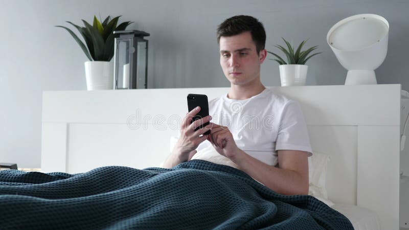 Man Using Smartphone while Lying in Bed Stock Image - Image of ...