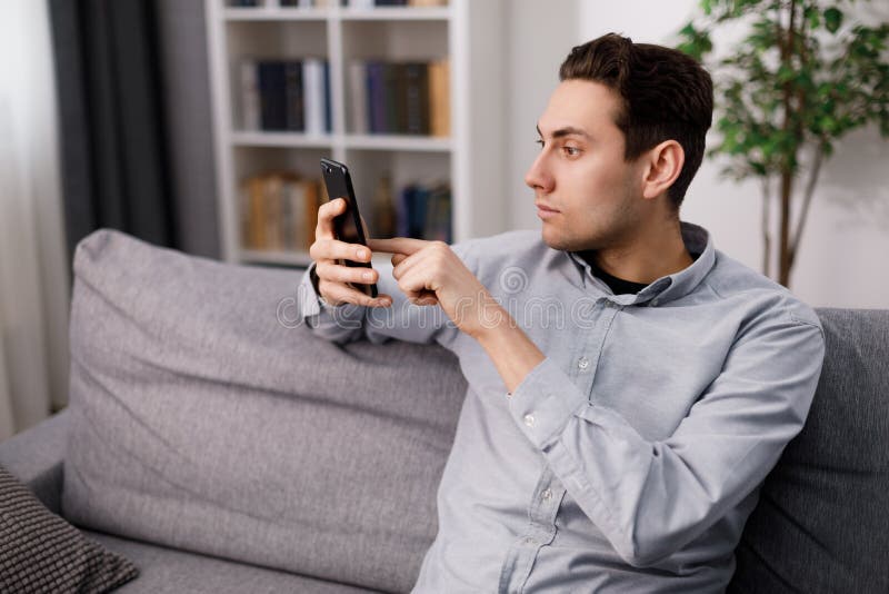 Man Using Smartphone on Sofa Stock Image - Image of internet, caucasian ...