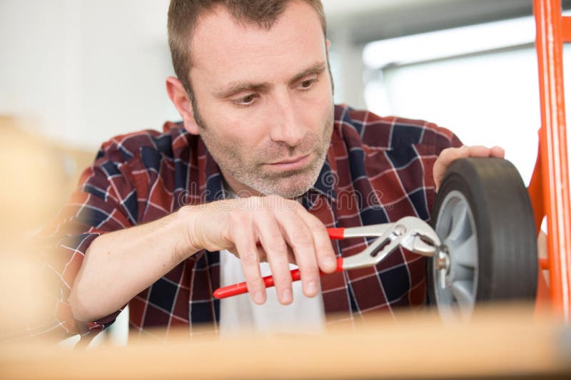 Man Using Spanner To Fix Trolley Wheel Stock Photo - Image of swivel ...
