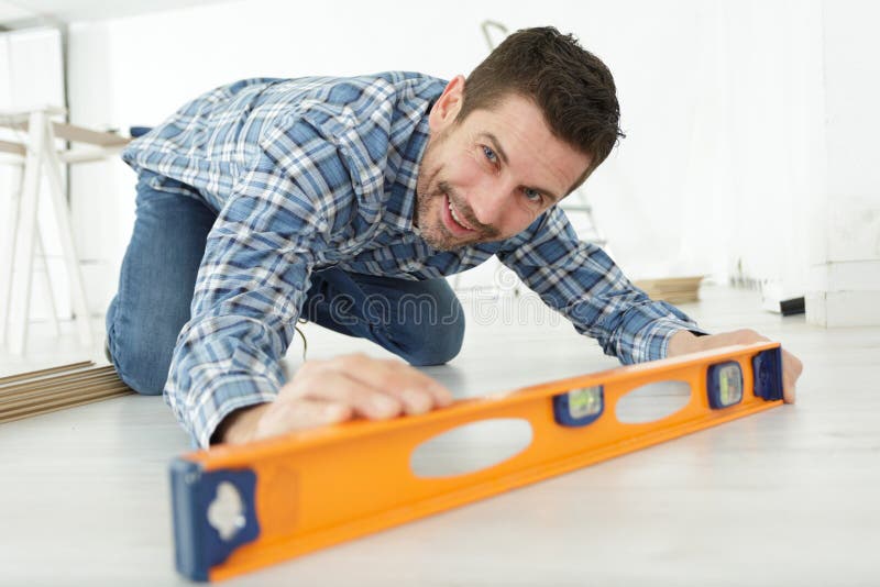 Man Using Spirit Level To Check New Flooring Stock Photo - Image of ...