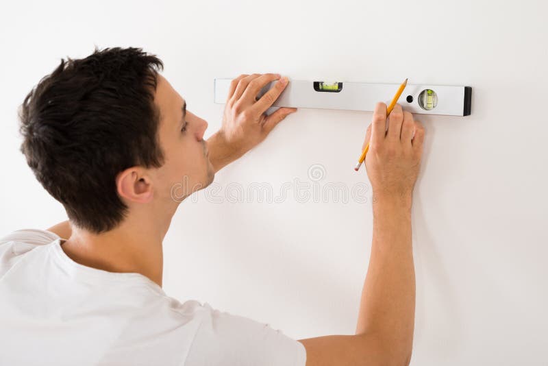 Man Using Spirit Level on White Wall Stock Image - Image of improvement ...