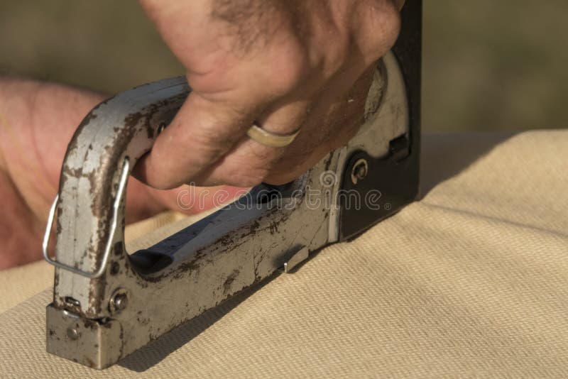 Man Using Stapler To Attach Cover Material. Stock Image - Image of ...