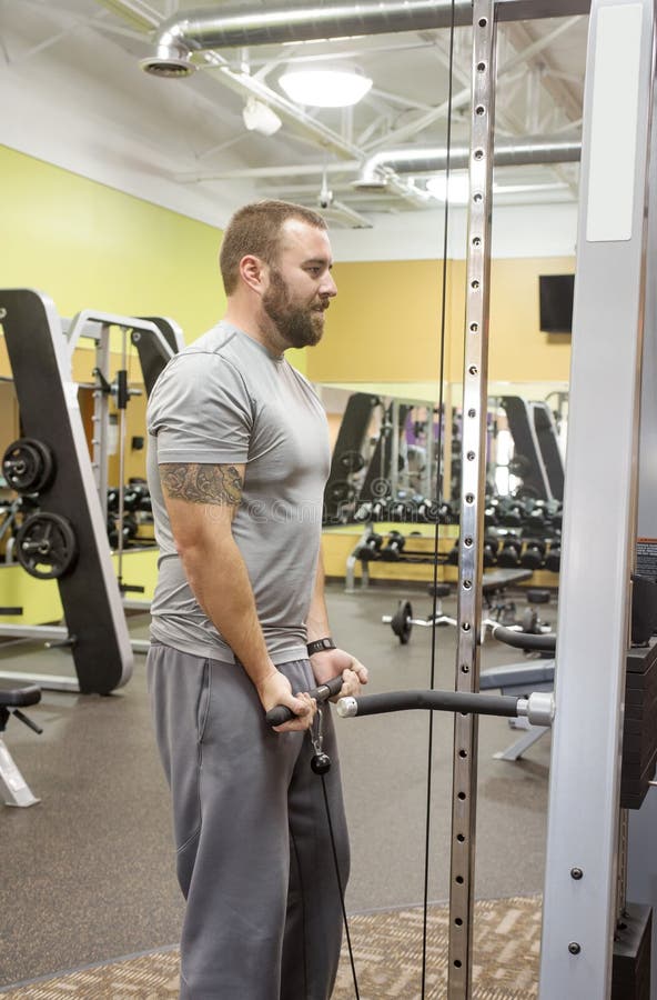 Man Using Seated Row Machine Stock Photo - Image of fitness, black ...