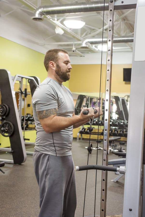 Man Using Seated Row Machine Stock Photo - Image of fitness, black ...