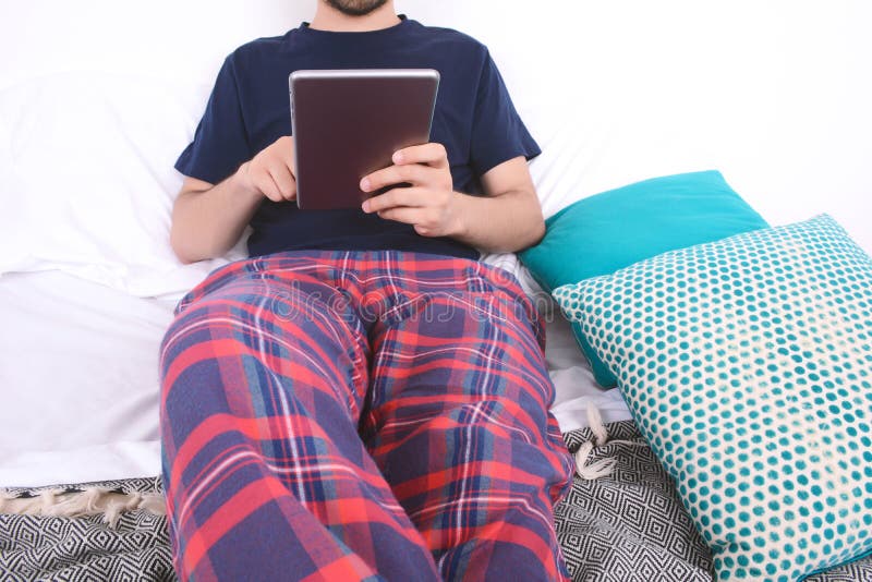 Man using tablet on bed. stock image. Image of reading - 86200229