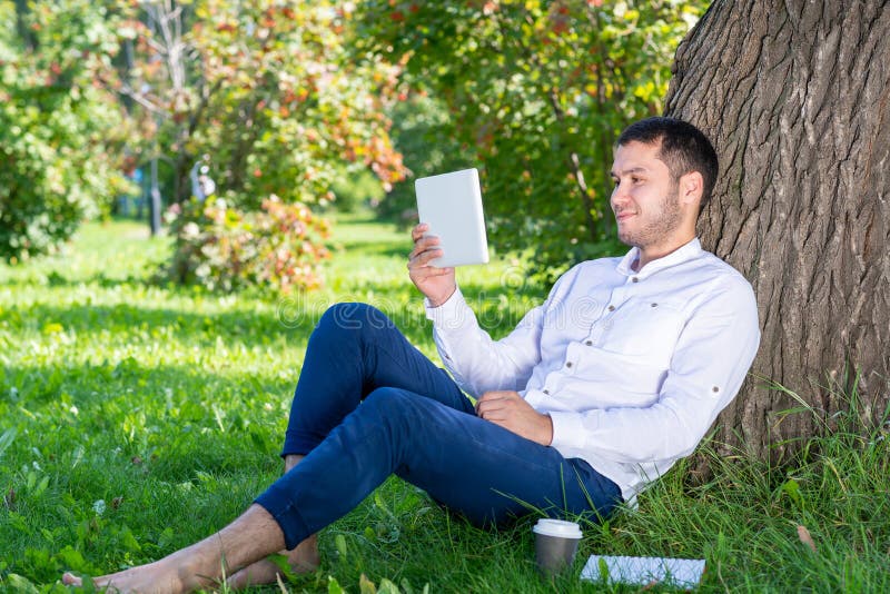 Man Using Tablet Computer Under Tree in Park Stock Photo - Image of ... Man Using Tablet Computer Under Tree in Park Stock Photo - Image of ...