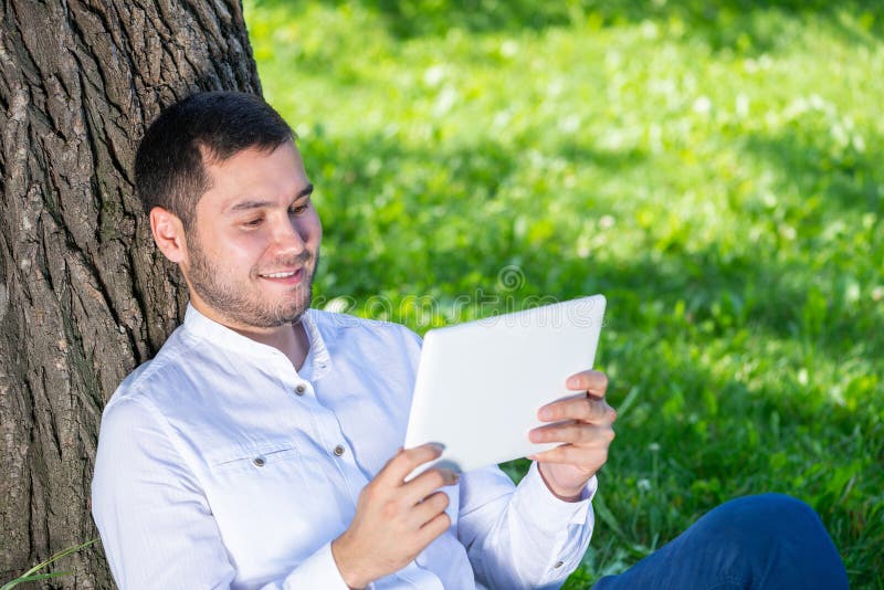 Man Using Tablet Computer Under Tree in Park Stock Image - Image of ...