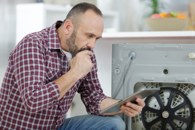 Man Using Tablet To Fix Washing Machine Stock Photo - Image of ...