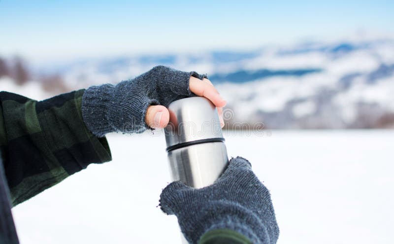 Man Holding Thermos in on a Snowy Mountain Stock Photo - Image of ...