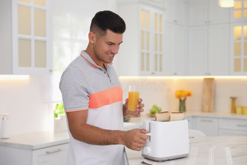 Man Using Toaster at Table in Kitchen Stock Image - Image of lunch ...