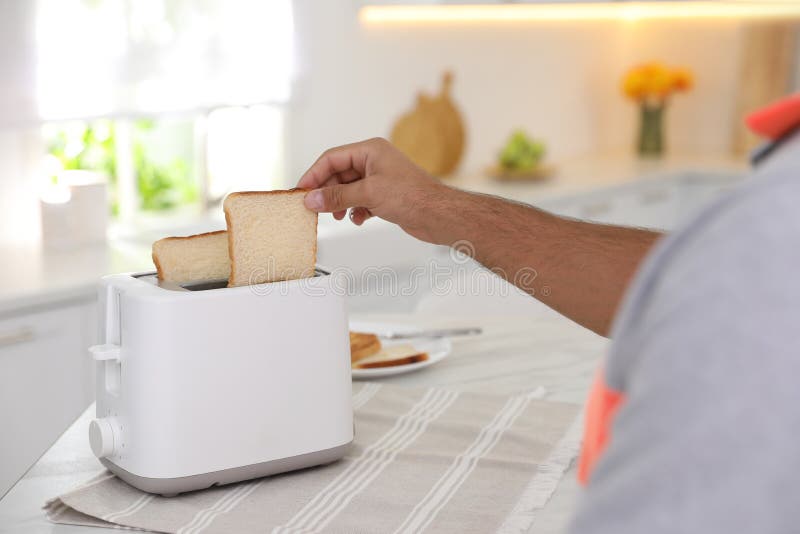 Man Using Toaster at Table in Kitchen, Closeup Stock Image - Image of ...