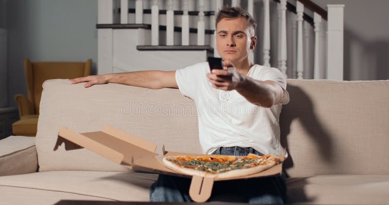 Man Using Tv Remote with Pizza in Lap Stock Video - Video of fresh ...