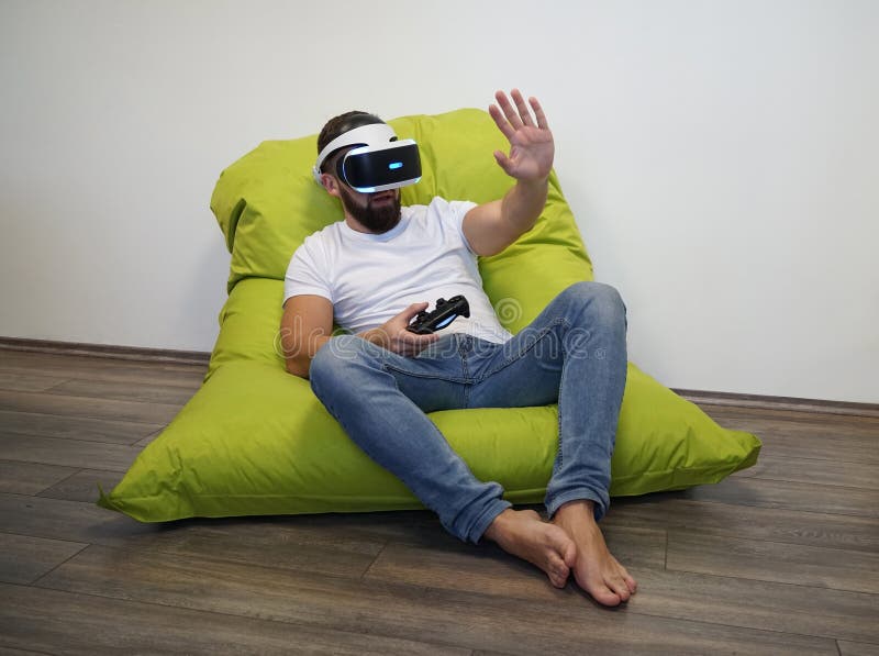 Man Using Virtual Reality in a Relaxed Bean Bag Gaming Setup Stock ...