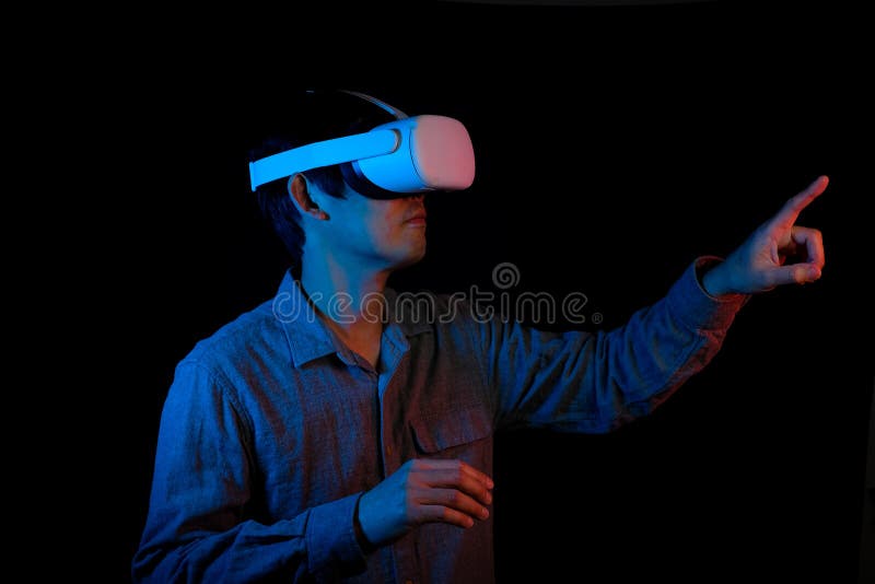 Man is Using VR or Virtual Reality on Black Background. he is Pointing ...