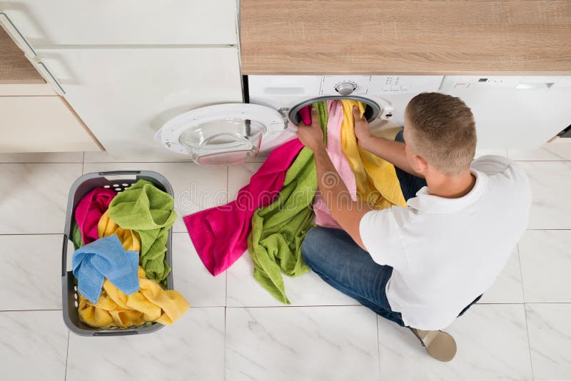Man Using Washing Machine stock image. Image of kneeling - 58556871