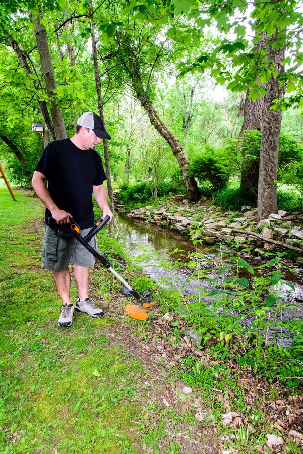 Man Using Weed Trimmer stock photo. Image of plain, grass - 55235482