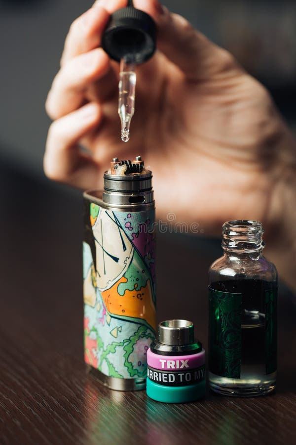 Man in a Vape Shop is Filling a Special Liquid in E-cigarette. Stock ...