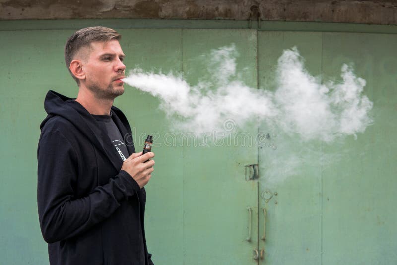 Man with Vape. Young Man Smoking an Electronic Cigarette Stock Photo ...