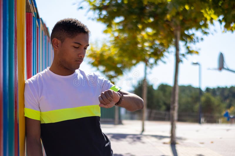 Man Waiting, Leaning on a Fence and Looking at the Clock Stock Image ...