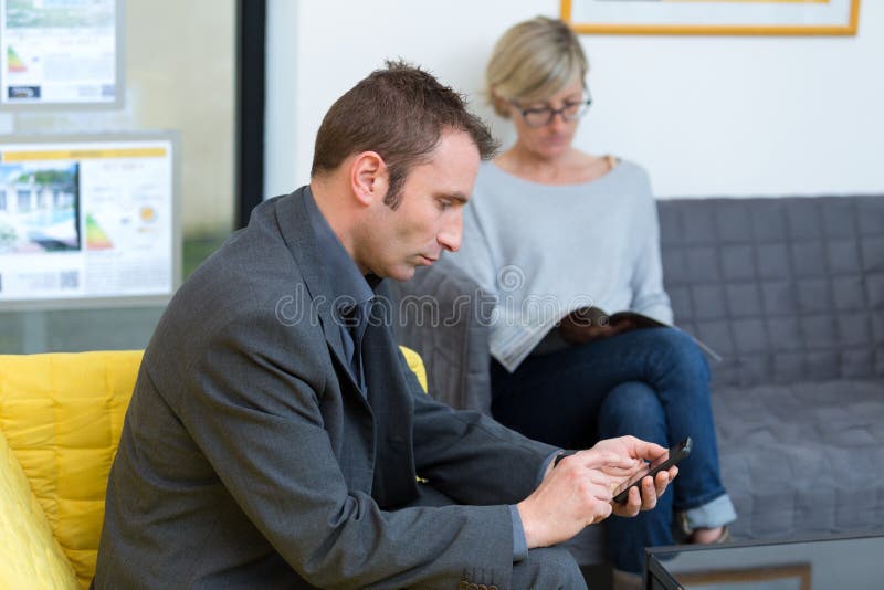 Man in Waiting Room Using Mobile Phone Stock Photo - Image of positive ...