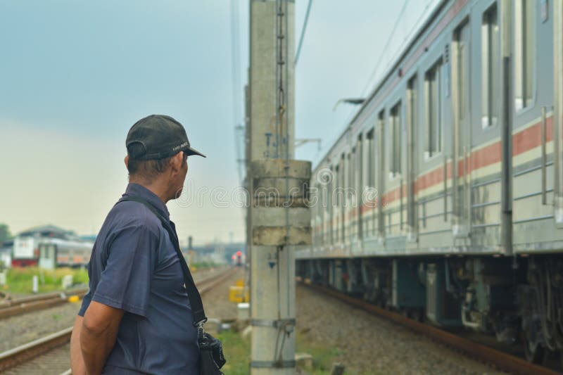 A Man Waiting for a Train To Pass by the Rails. Editorial Photography ...