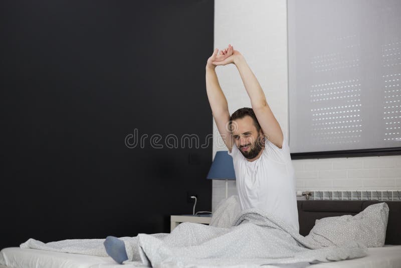 Man Waking Up in His Bedroom and Stretching Stock Photo - Image of ...