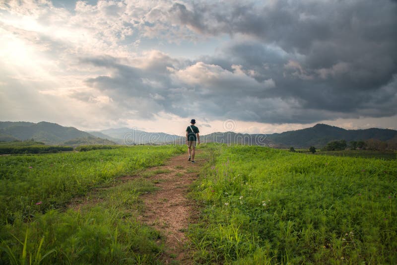 A Man Walking Alone on the Road with Dramatic Sky. Stock Photo - Image ...