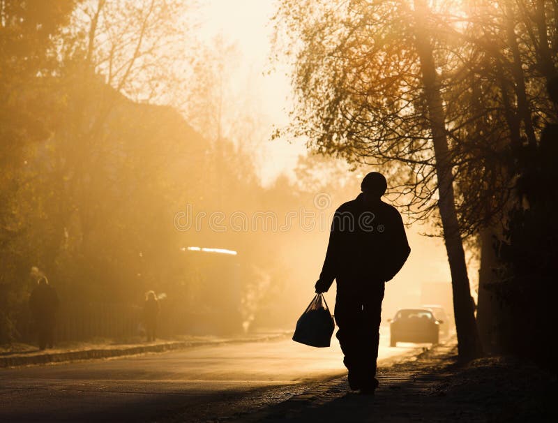 Man Walking Along the Road, Backlit at Sunset Stock Photo - Image of ...