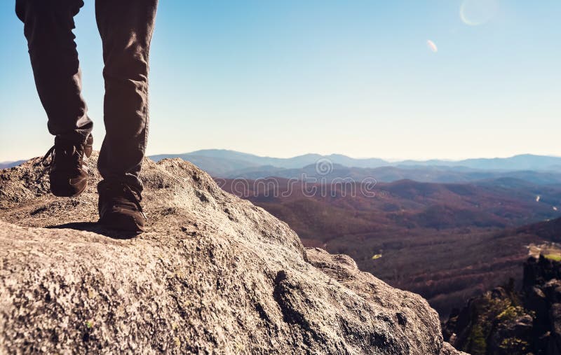 Man Walking on the Edge of a Cliff High Above the Mountains Stock Image ...