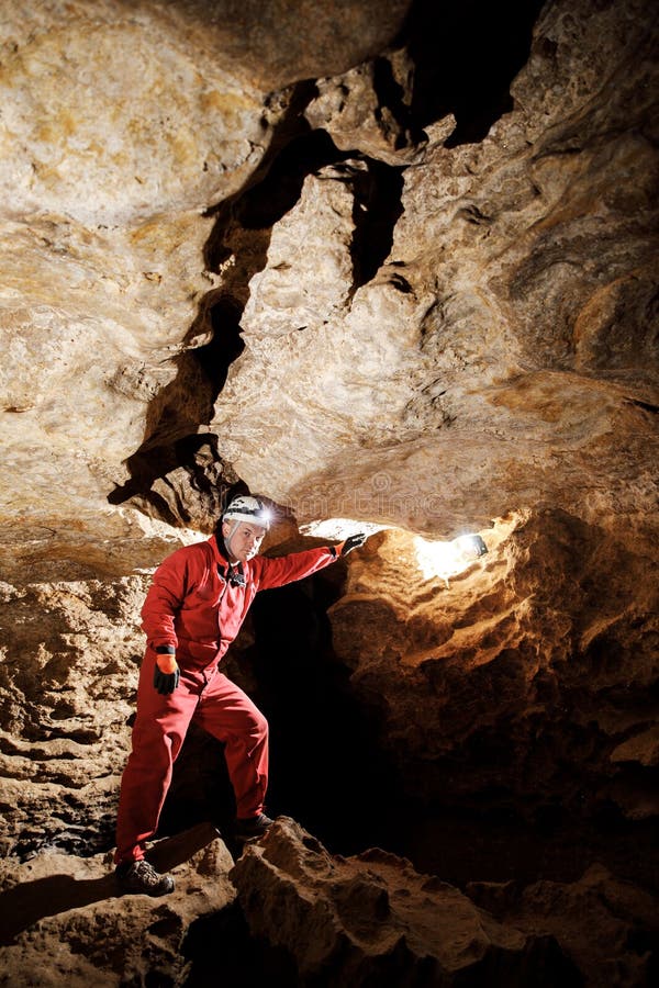 Man Walking and Exploring Dark Cave with Light Headlamp Underground ...