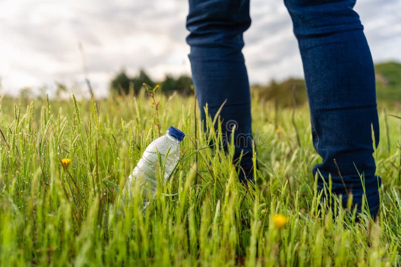 Man Walking through a Green Field and Throwing Waste and Garbage that ...
