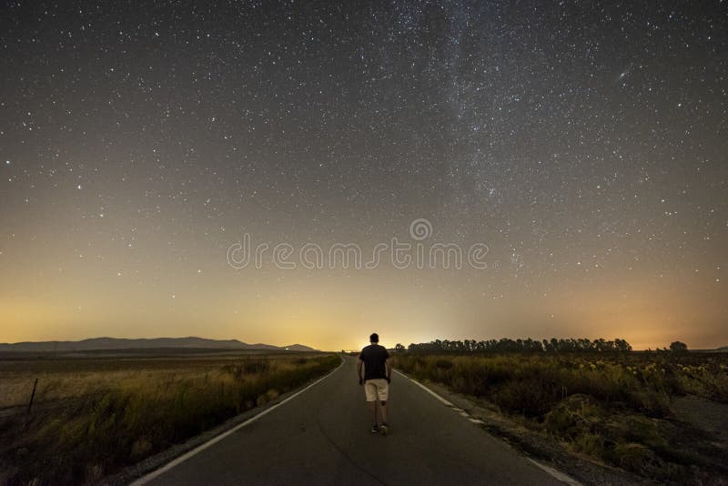 Man Walking in the Middle of an Empty Road Under a Starry Night Sky ...