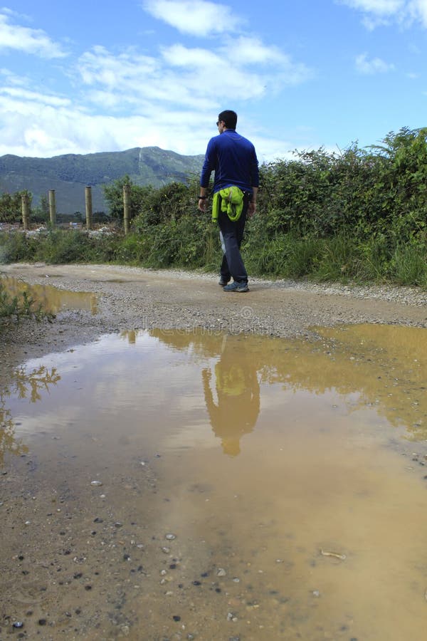 Man Walking On The Road With Reflection In The Puddle Stock Photo ...