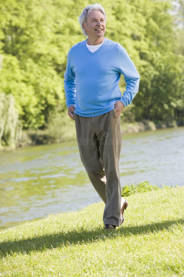 Man Walking Outdoors at Park by Lake Smiling Stock Photo - Image of ...