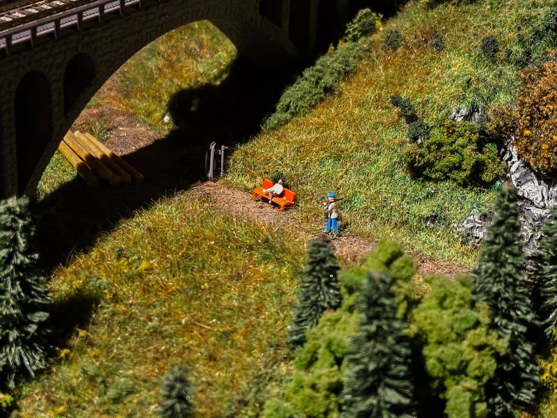 A Man is Walking on a Path in a Field with a Toy Train Set Stock Image ...