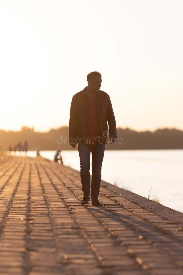 Man walking on river edge stock photo. Image of alone - 231865586