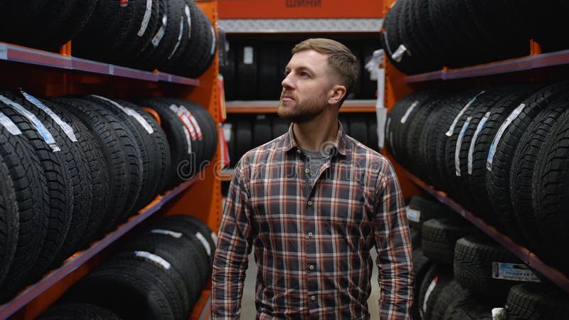A Man Choose New Tire for Car at Auto Parts Store. Concept of Choosing ...