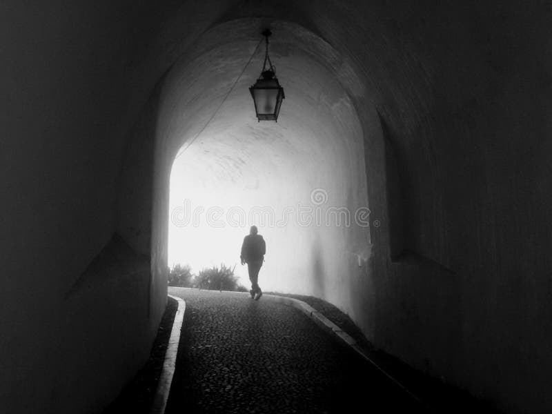 Man walking towards light stock image. Image of photograph - 265884963