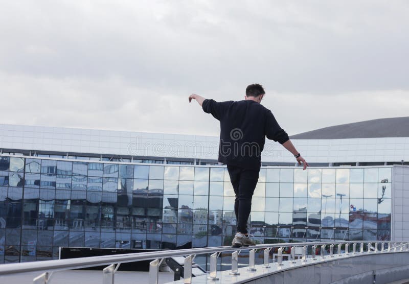 The Guy Walks Along the Railing at a Height. Stock Image - Image of ...