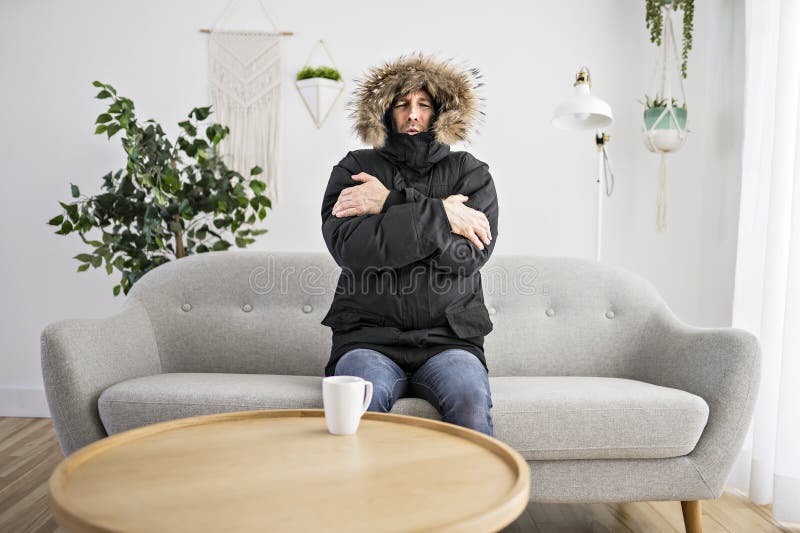 Man with Warm Clothing Feeling the Cold Inside House on the Sofa Stock ...
