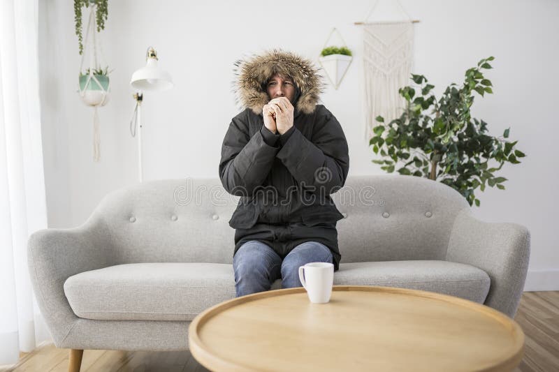 Man with Warm Clothing Feeling the Cold Inside House on the Sofa Stock ...